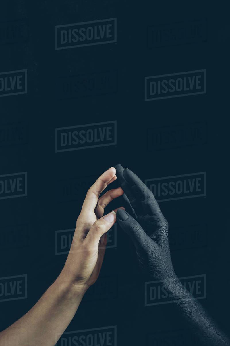 Cropped view of woman touching with black demon hand isolated on black ...