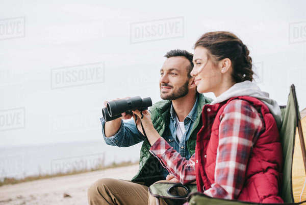 Side view of couple with binoculars having camping - Royalty-free Stock ...