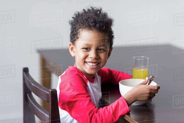 Cute smiling African American kid eating healthy breakfast - Royalty ...