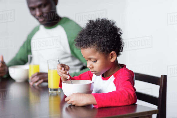 Happy African American father and little son eating breakfast - Royalty ...