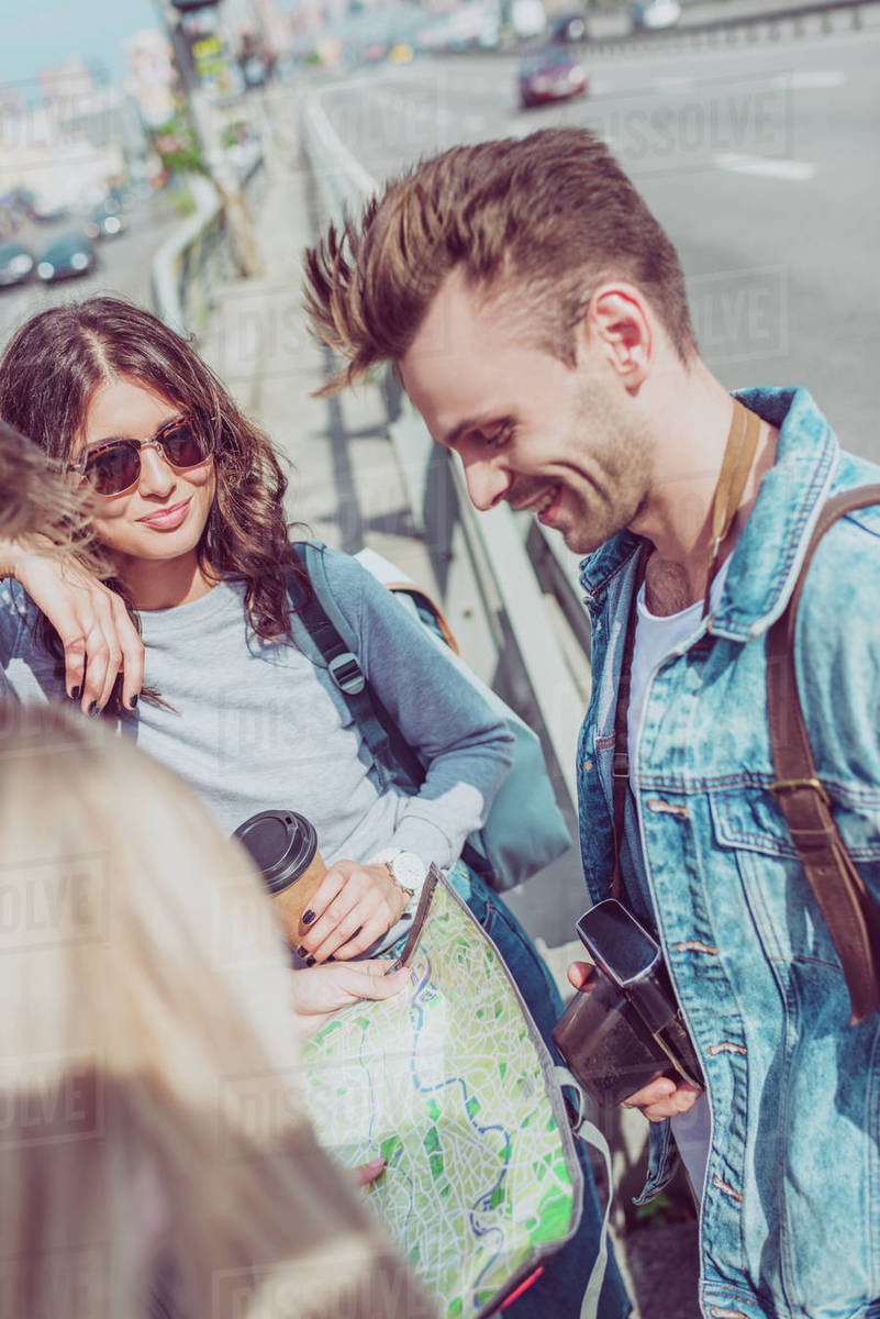 Travelers looking for destination on map during trip in new city ...