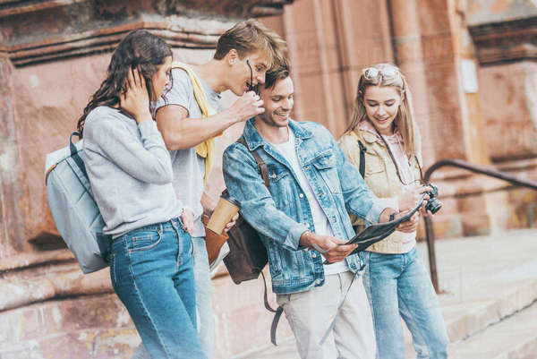 Cheerful tourists looking at map in city - Royalty-free Stock Photo ...