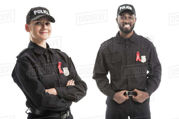 Happy police officers with aids awareness red ribbons looking at camera ...