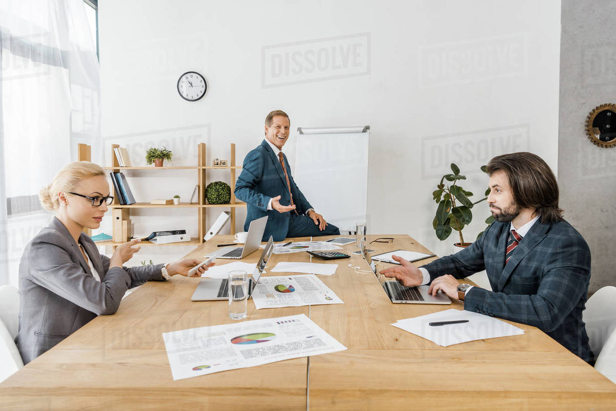 Business people sitting at table during meeting in office - Royalty ...