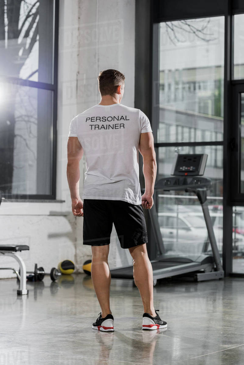 Back view of athletic bodybuilder in shirt with text personal trainer ...