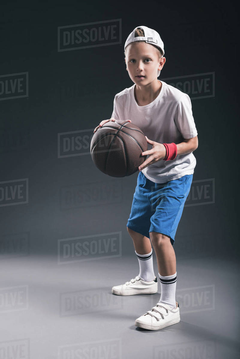 Stylish boy playing basketball on grey background - Royalty-free Stock ...