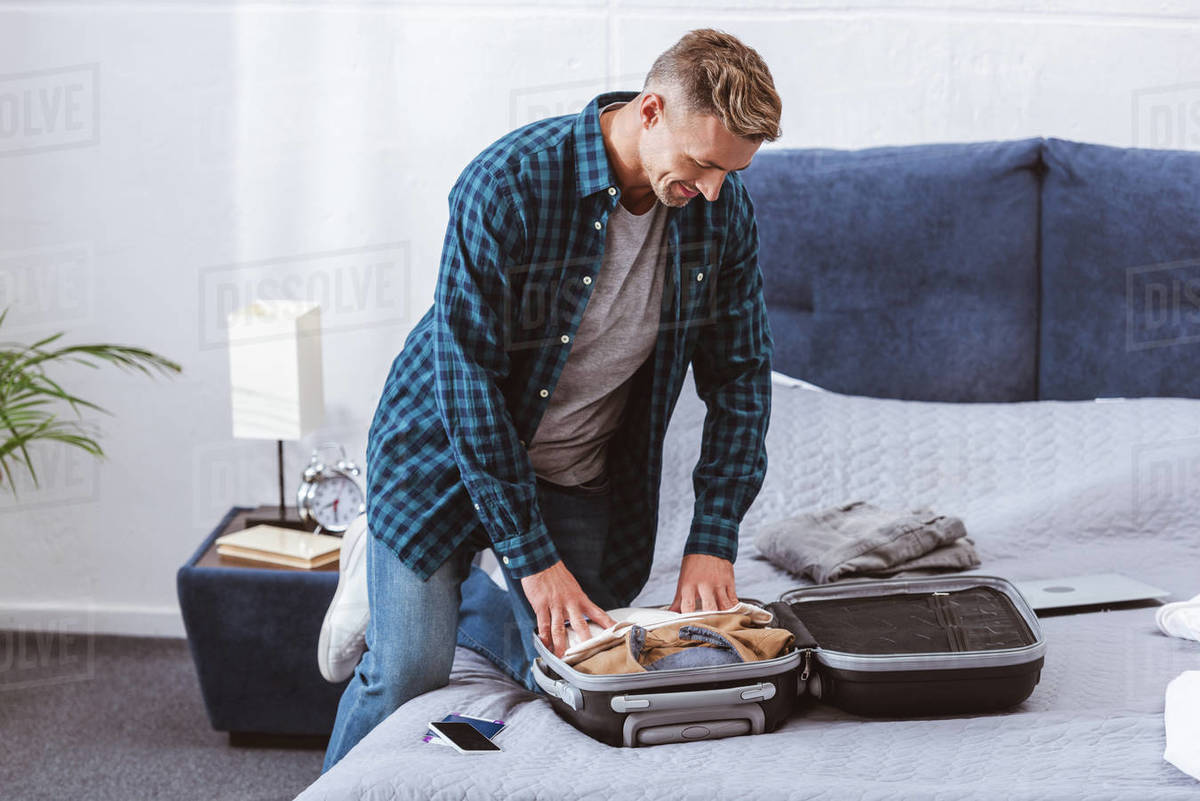 Adult male traveler packing luggage in bedroom at home - Stock Photo ...