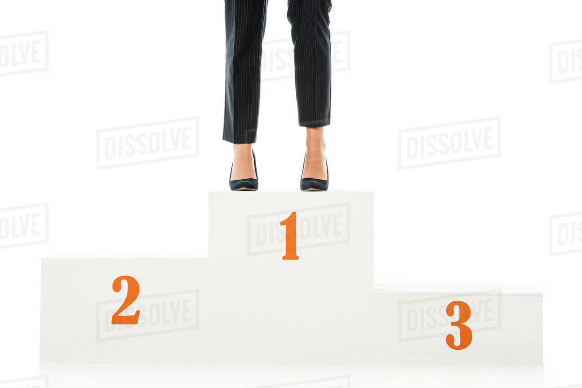 cropped view of businesswoman standing on winners podium isolated on ...