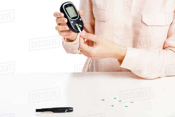 cropped image of woman putting strip into glucometer isolated on white ...