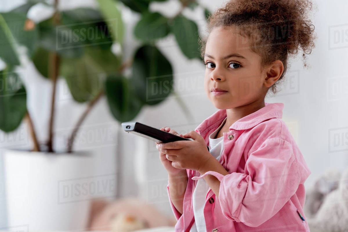 Close up of African American child sitting with tv remote - Stock Photo ...