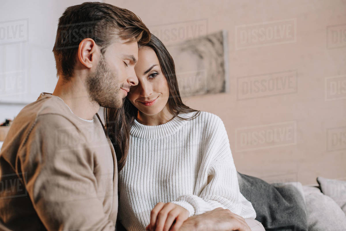 Young couple cuddling on couch at home - Royalty-free Stock Photo ...