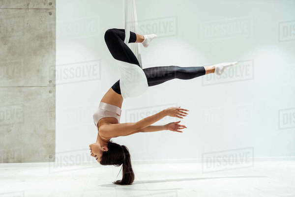 Beautiful relaxed girl practicing antigravity yoga in inversion ...