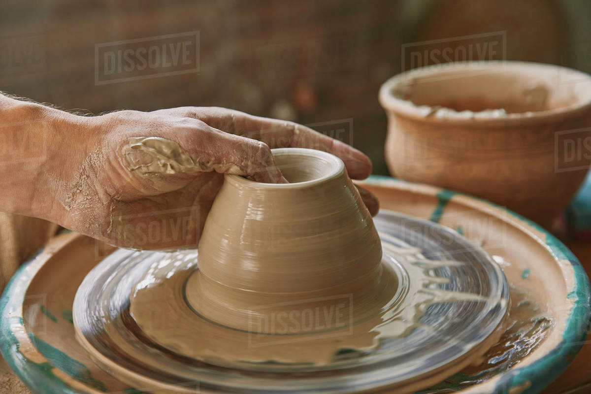 cropped image of professional potter working on pottery wheel at ...