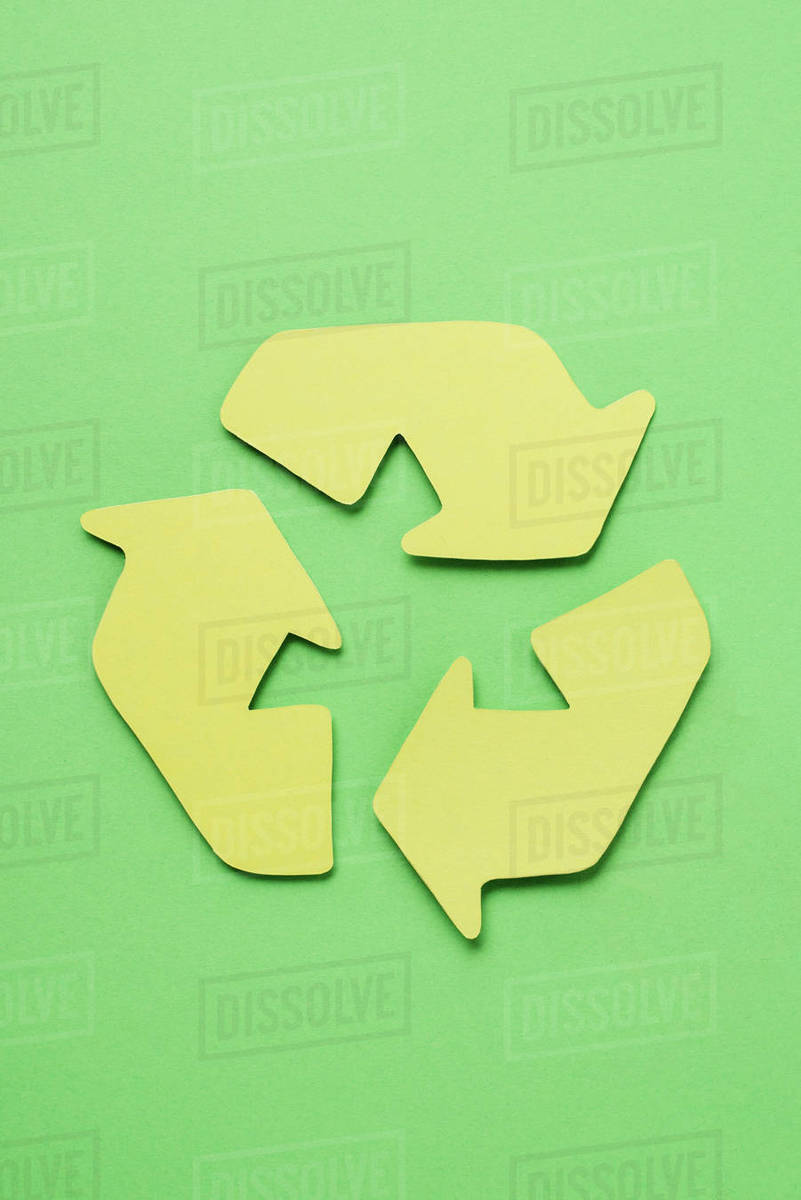 Top view of yellow recycle sign with arrows on green background - Stock ...