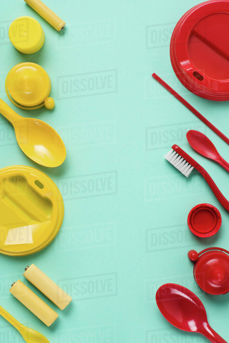 Flat lay with red and yellow disposable plastic wares arranged on blue ...