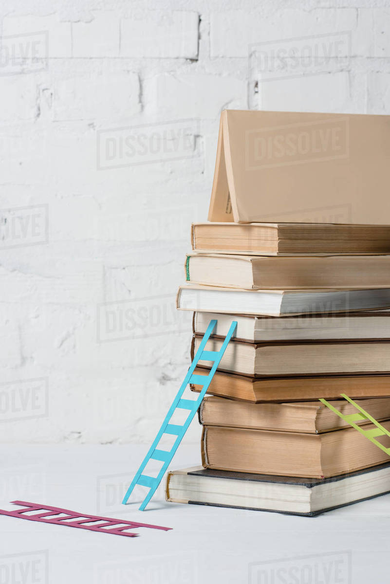 close-up view of pile of books and small colorful step ladders - Stock ...
