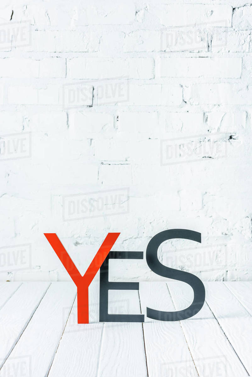 "yes" lettering with decorative red and black letters on wooden surface ...