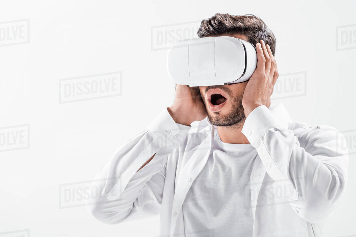 close up of scared adult man in total white wearing virtual reality ...