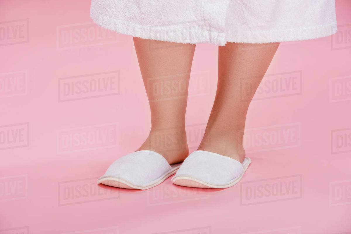 Cropped shot of young overweight woman in white slippers and bathrobe ...