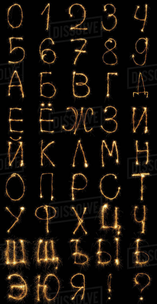 Close up view of light Russian alphabet and numbers on black background ...
