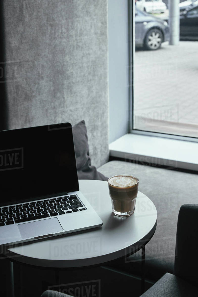 Laptop with black screen and cup of coffee on table in cafe - Stock ...