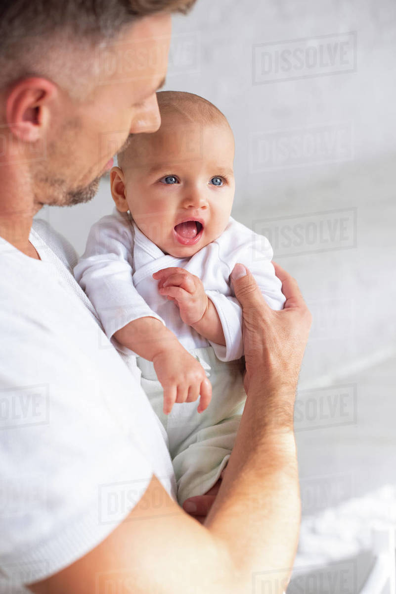Selective focus of surprised baby in hands of father - Stock Photo ...