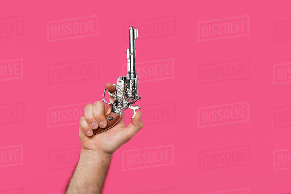 cropped shot of man holding revolver isolated on pink - Stock Photo ...