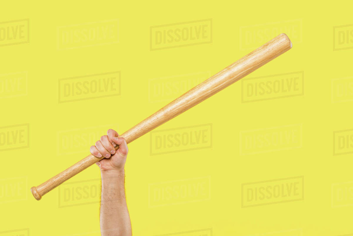 cropped shot of person holding baseball bat isolated on yellow ...
