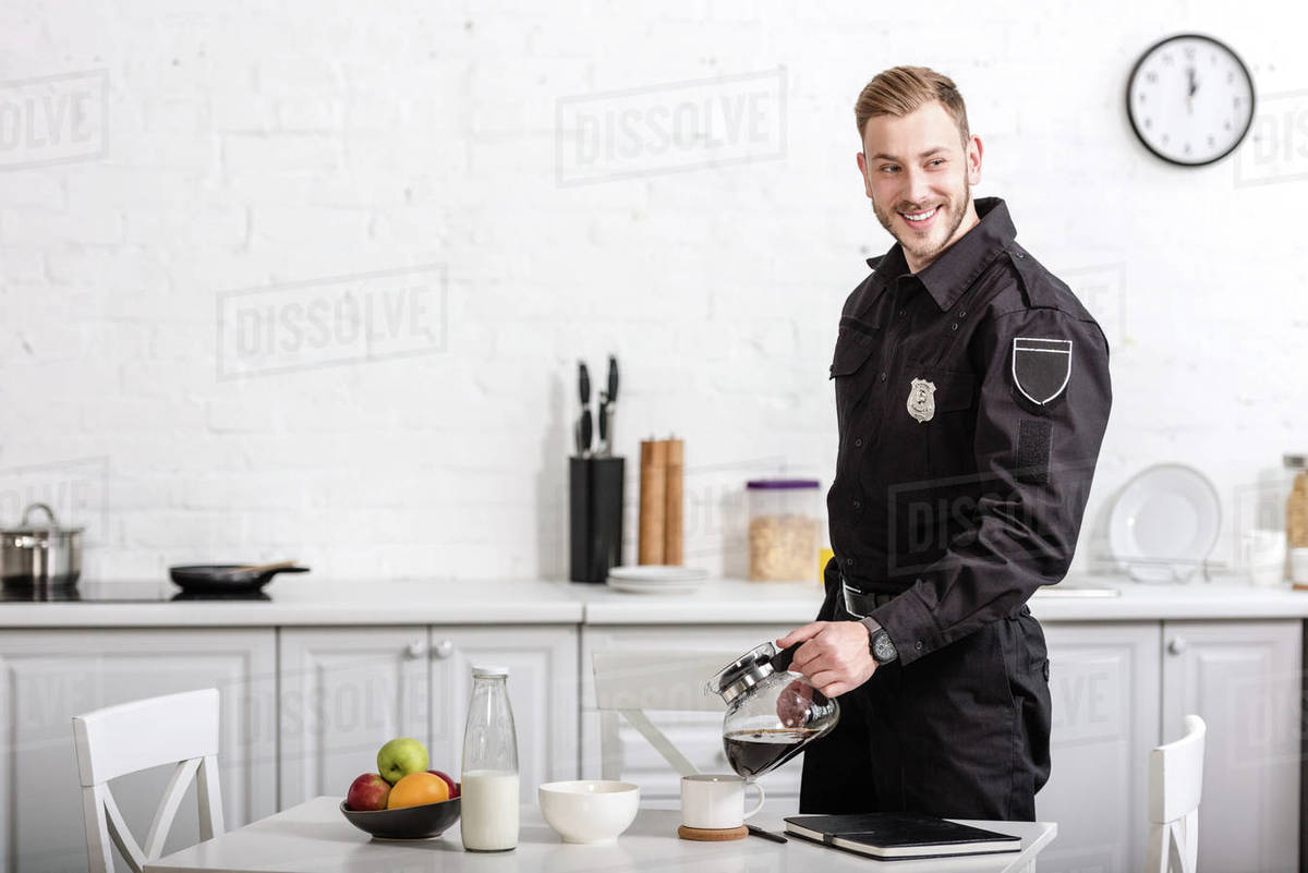 smiling handsome policeman pouring filtered coffee from glass pot at ...