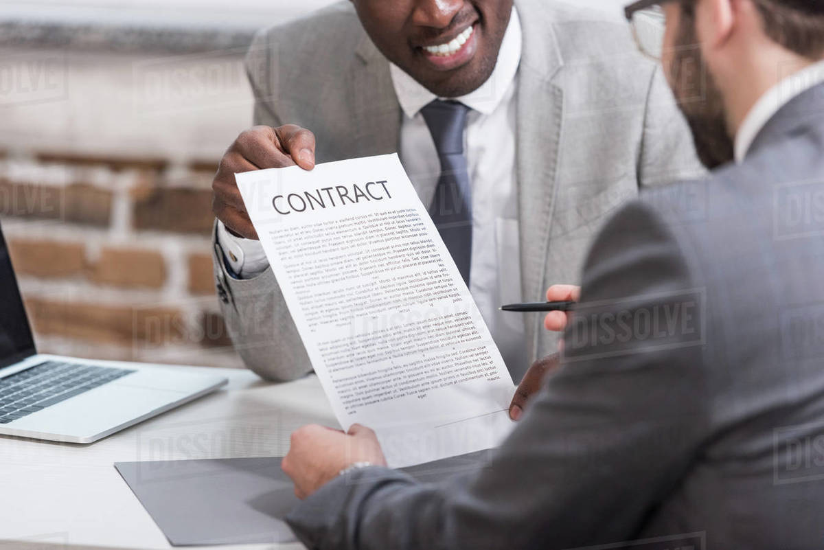 cropped view of african american businessman showing contract to ...