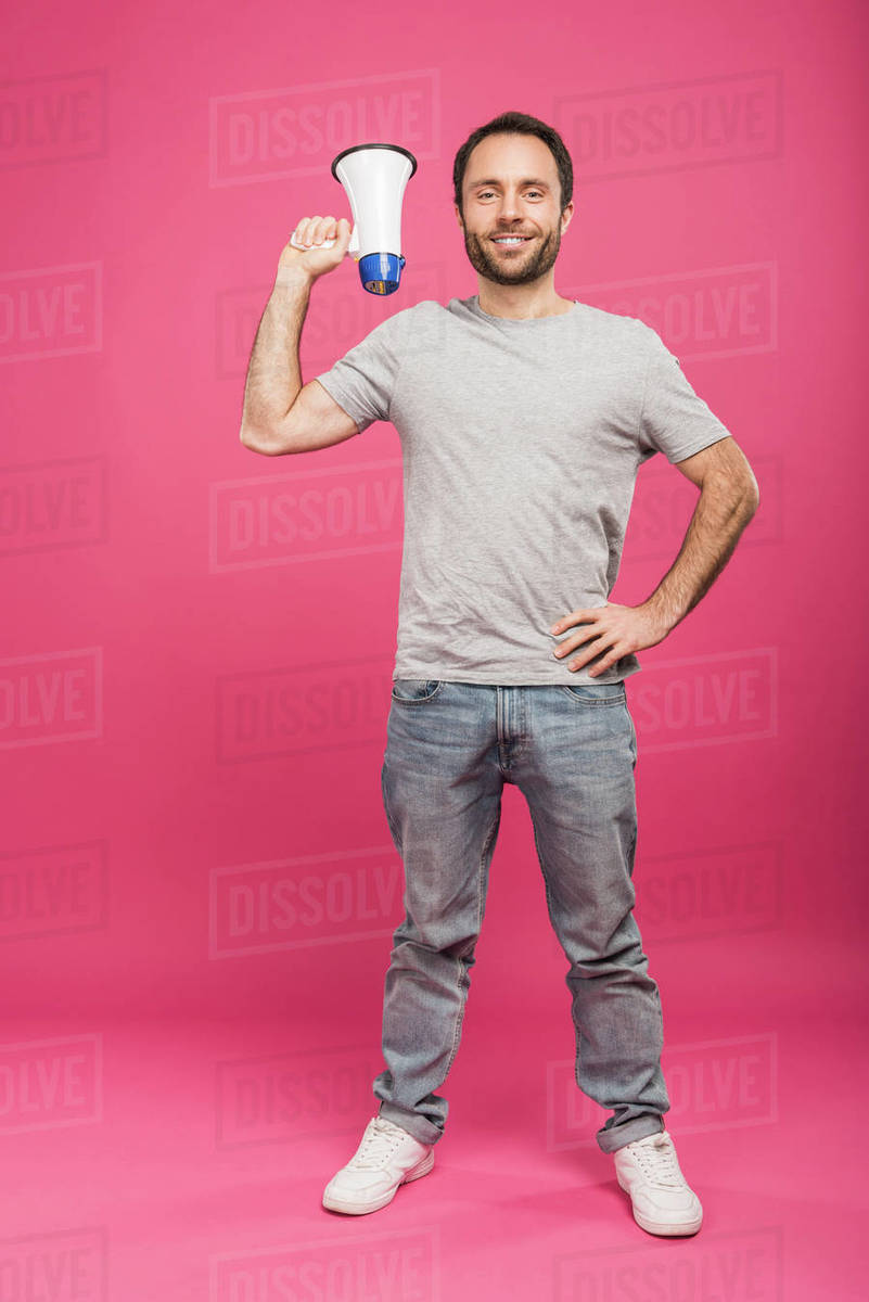 Handsome cheerful man holding megaphone, isolated on pink - Royalty ...