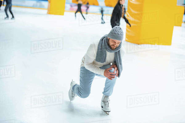Man injured knee while skated on ice rink - Stock Photo - Dissolve