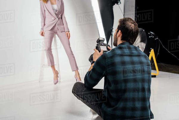 Cropped shot of photographer shooting beautiful young female model in ...