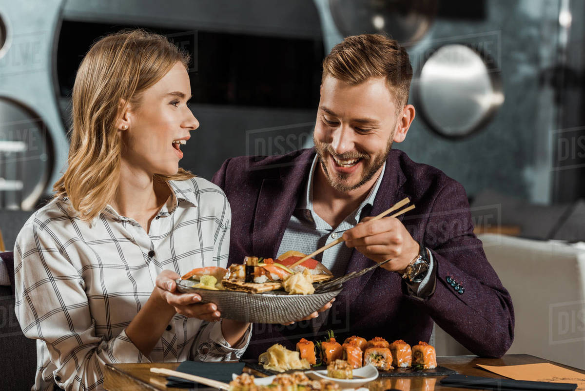 Beautiful surprised woman holding plate with delicious seafood while ...