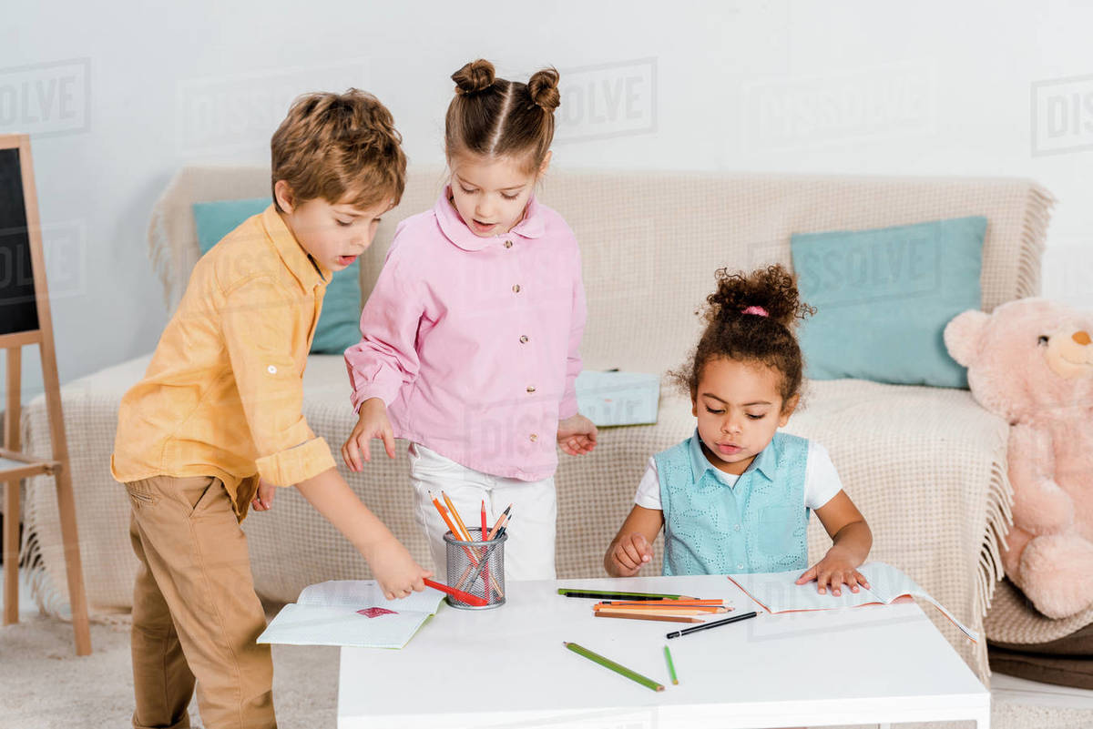 High angle view of adorable multiethnic children drawing together ...
