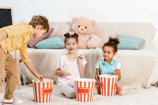 Adorable multiethnic kids eating popcorn together - Royalty-free Stock ...