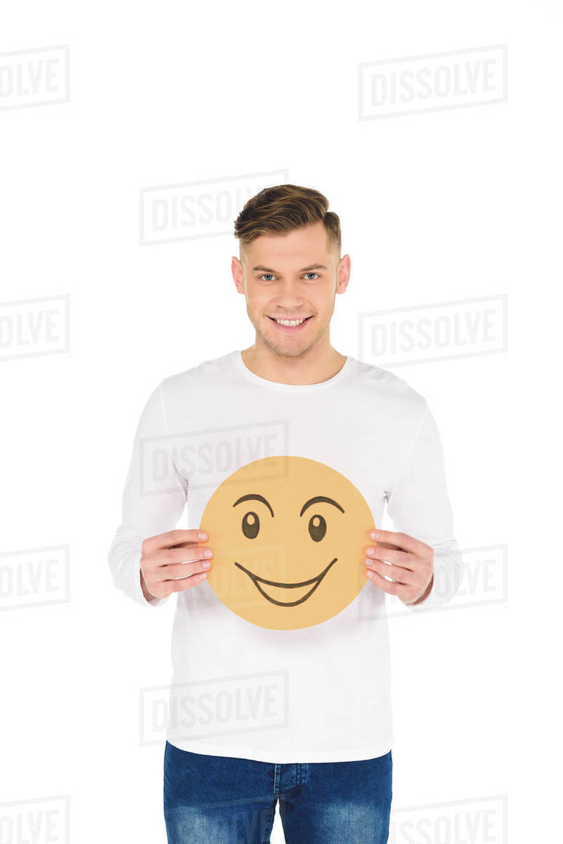 Handsome man holding round yellow card with cunning face expression ...