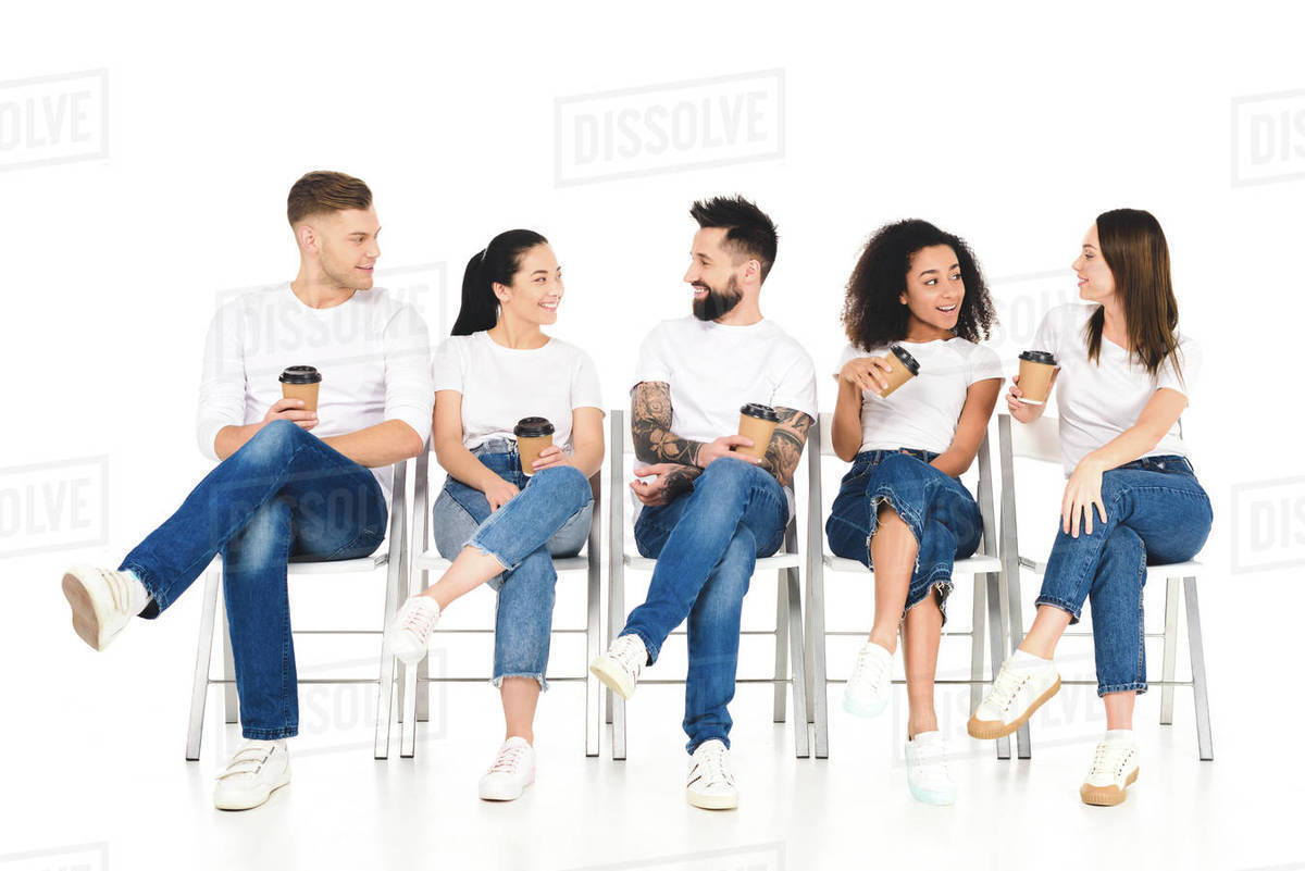 Multicultural group of people sitting on chairs with coffee to go and ...