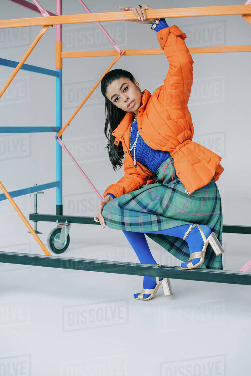 Fashionable African American female model in orange winter jacket ...