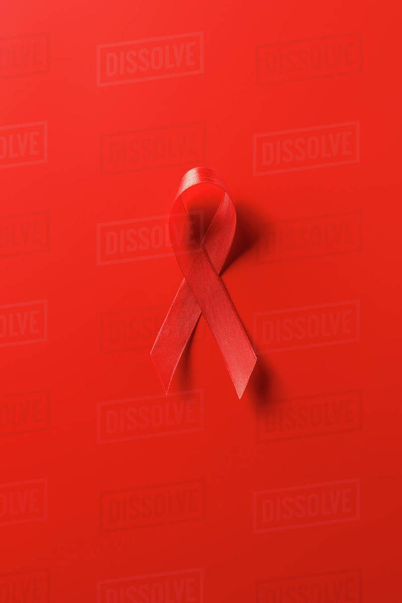 Top view of aids awareness red ribbon on red background - Royalty-free ...