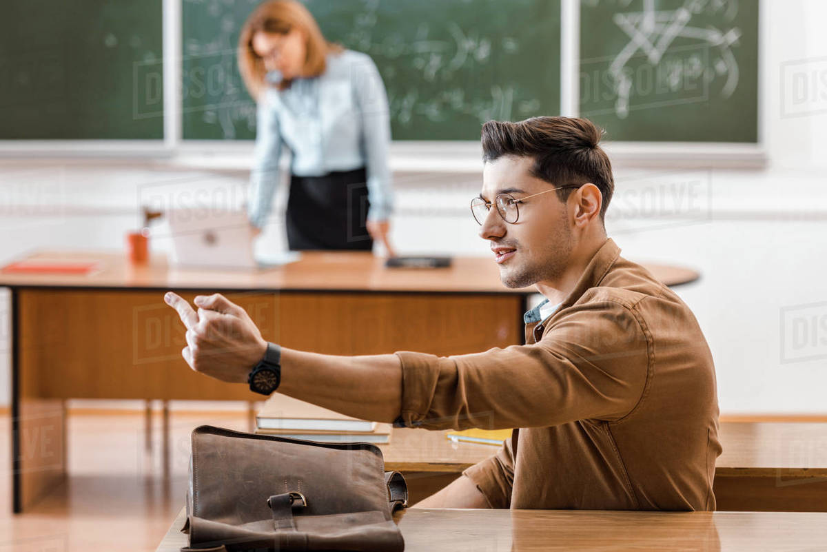 Student showing middle finger in classroom with female teacher on ...