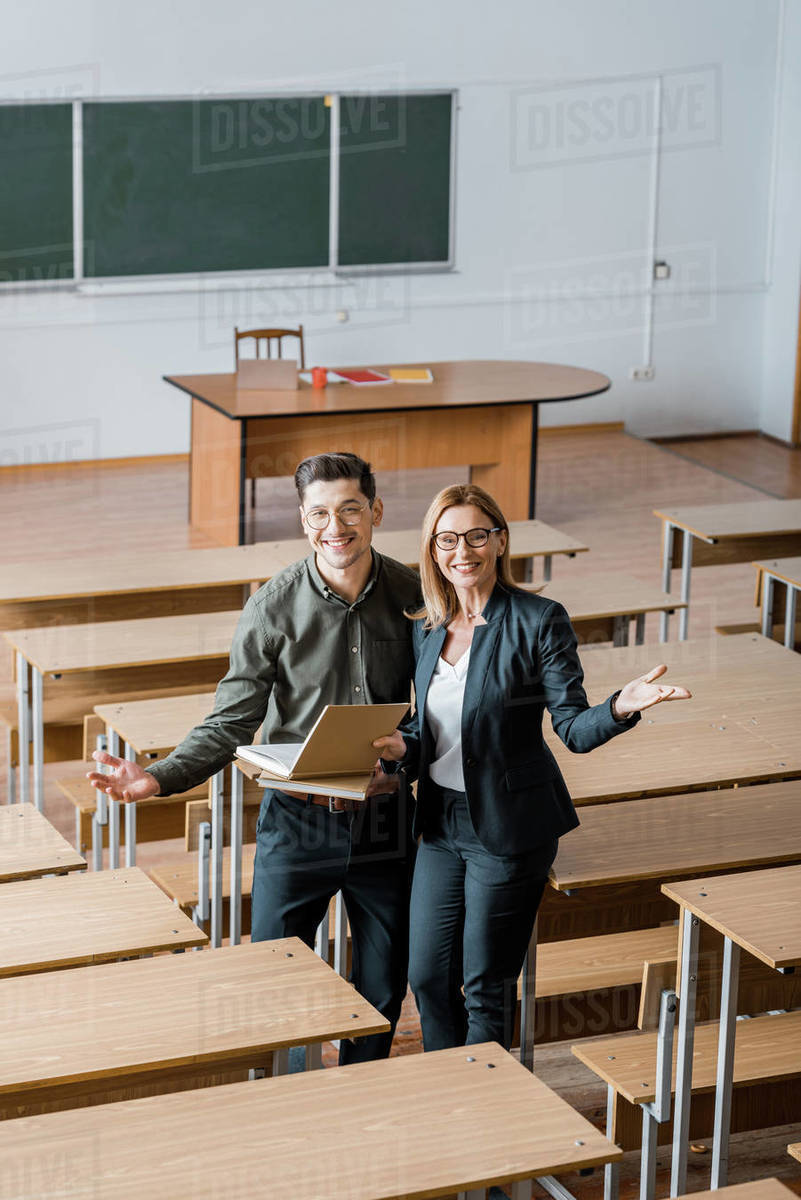 Happy male student and female teacher with outstretched hands holding ...