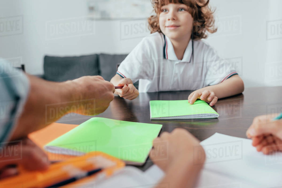 Father passing pen to adorable curly son - Royalty-free Stock Photo ...