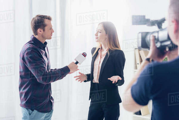 Beautiful businesswoman in formal wear giving interview to journalist ...