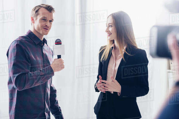 Beautiful businesswoman in suit giving interview to journalist in ...
