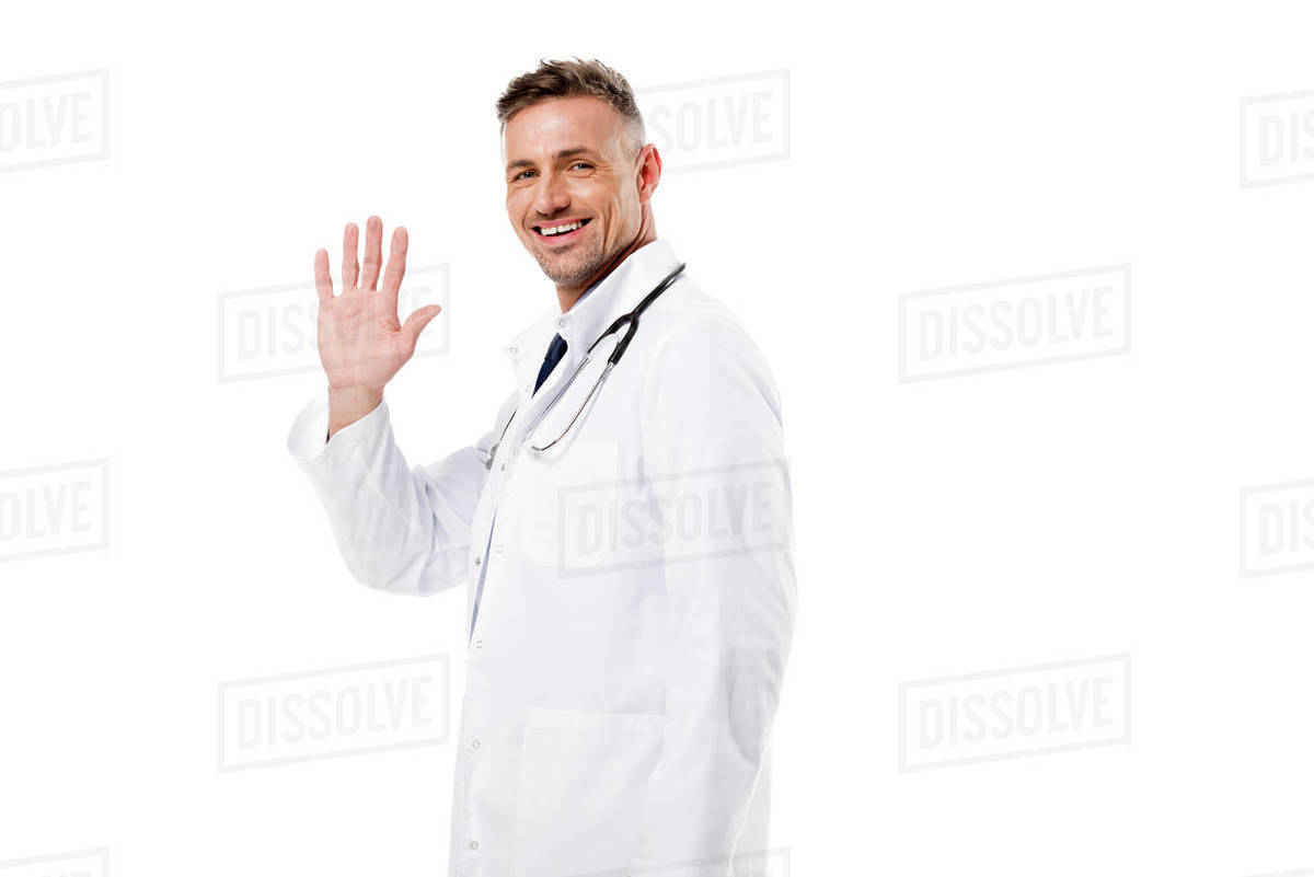 Handsome doctor waving and looking at camera isolated on white - Stock ...