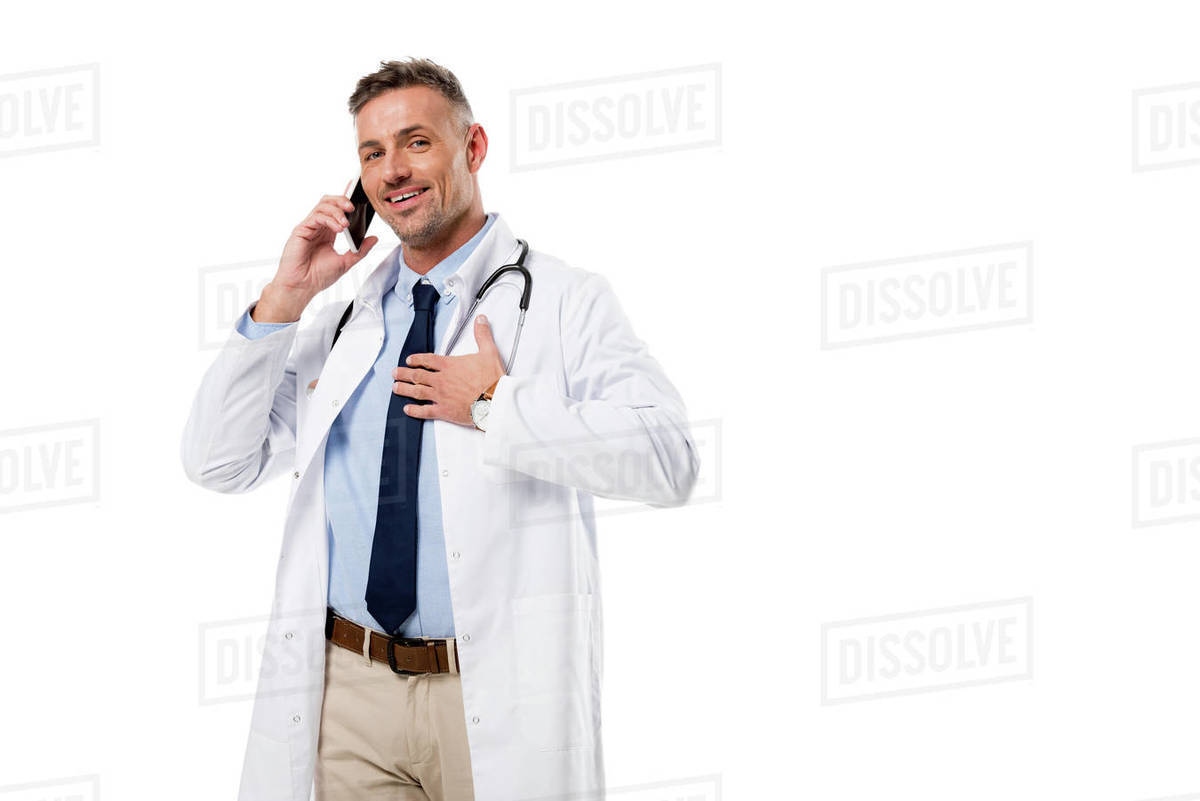 Smiling doctor talking on smartphone and looking at camera isolated on ...