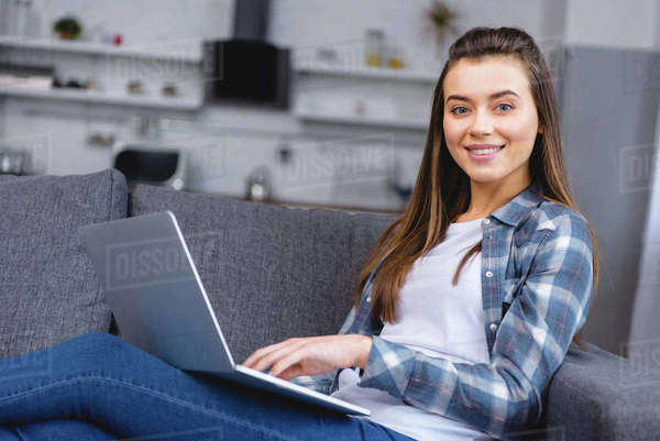 Attractive happy girl using laptop and smiling at camera - Royalty-free ...