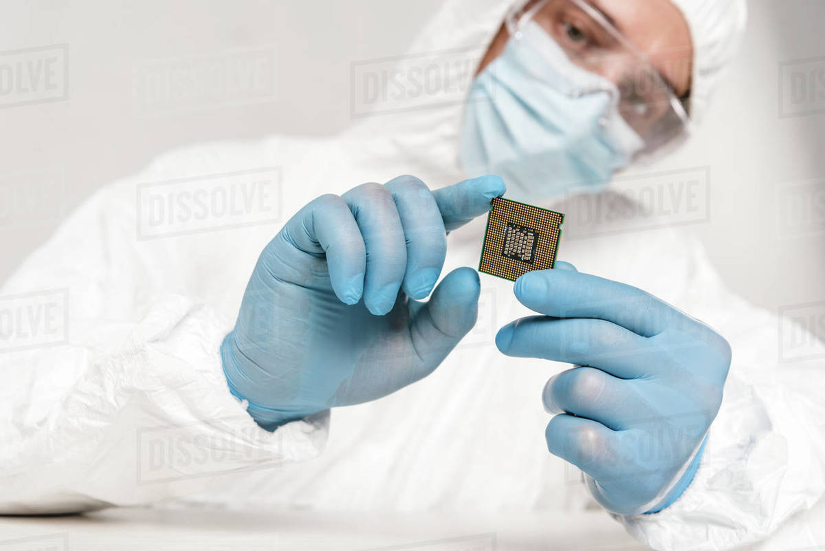 Selective focus of microprocessor in hands of scientist in googles on ...