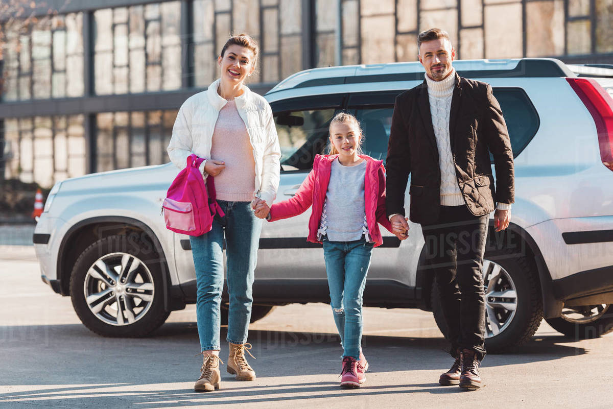 Happy family walking and holding hands near car - Royalty-free Stock ...
